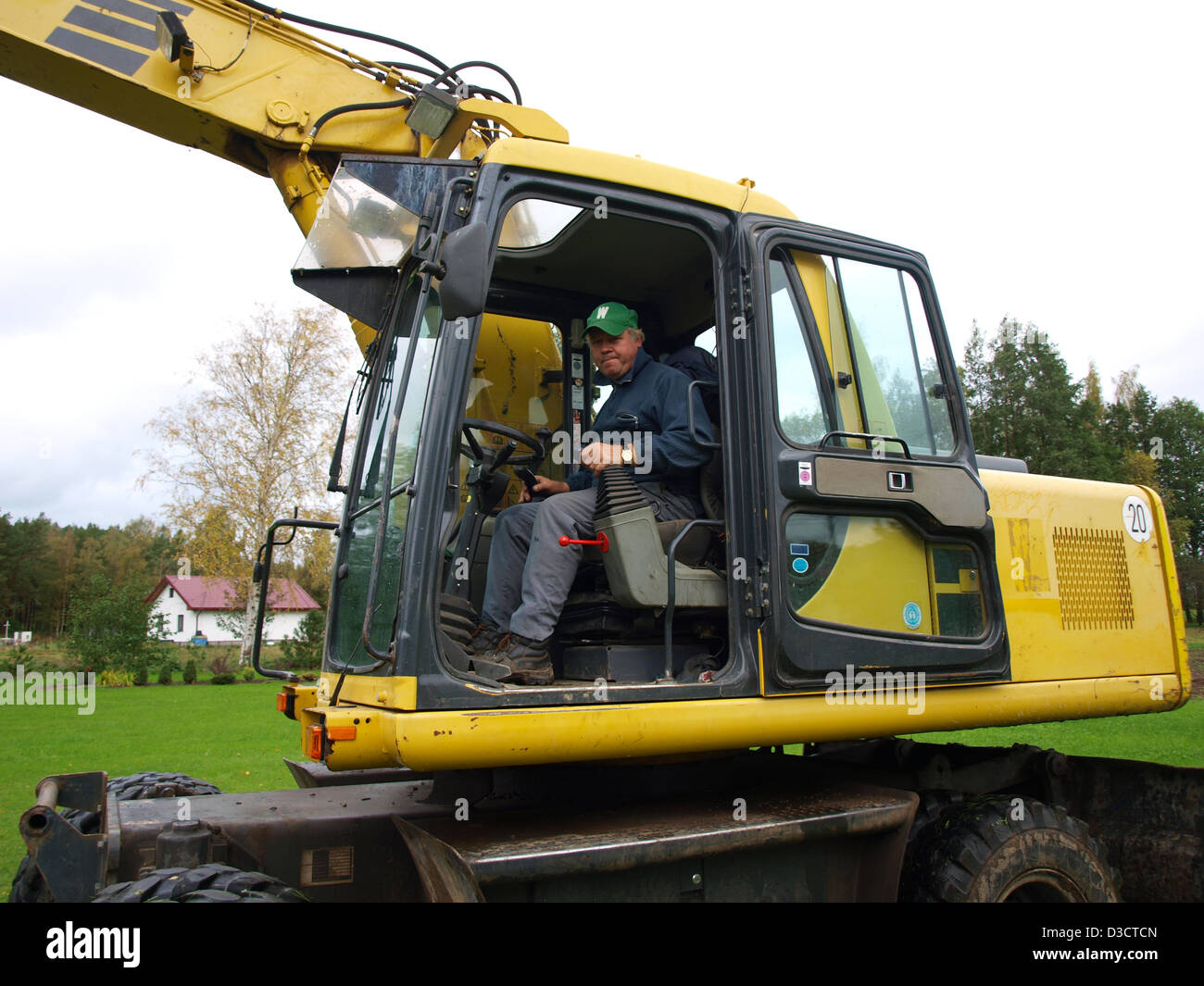 Hydraulic excavator driving and working on country farm Stock Photo - Alamy