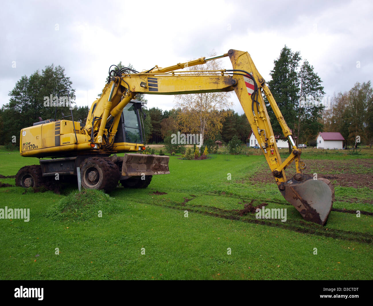 Hydraulic excavator driving and working on country farm Stock Photo - Alamy