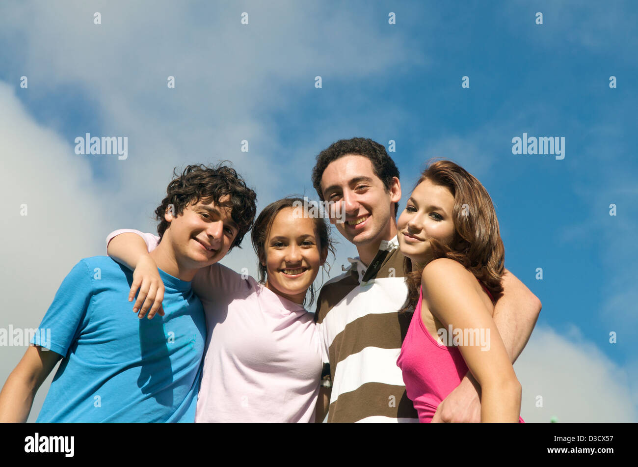 Group of 4 friends under blue sky Stock Photo - Alamy