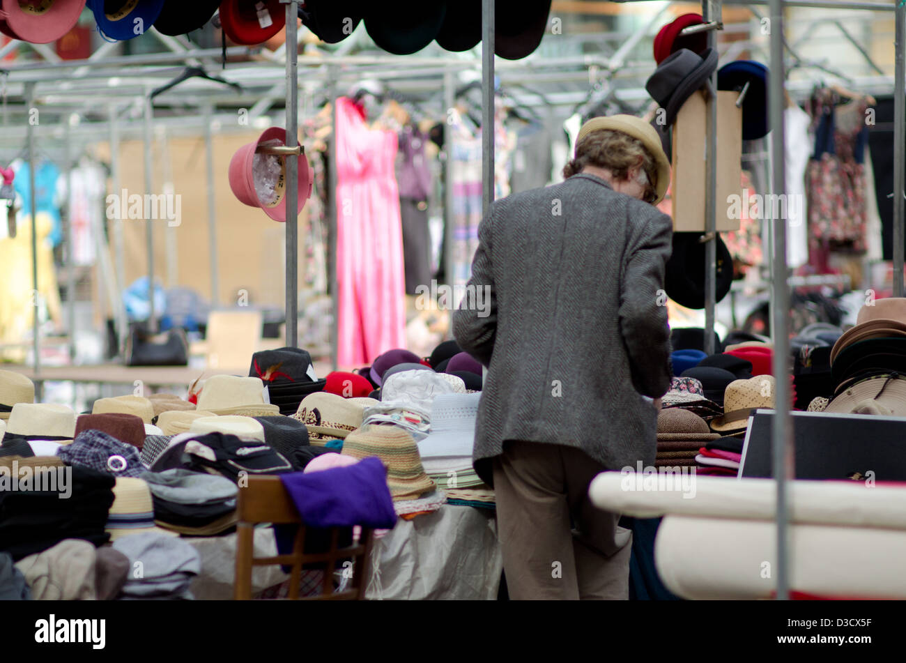 Male wearing hat setting up a hat stall in Spitalfields Market Stock ...