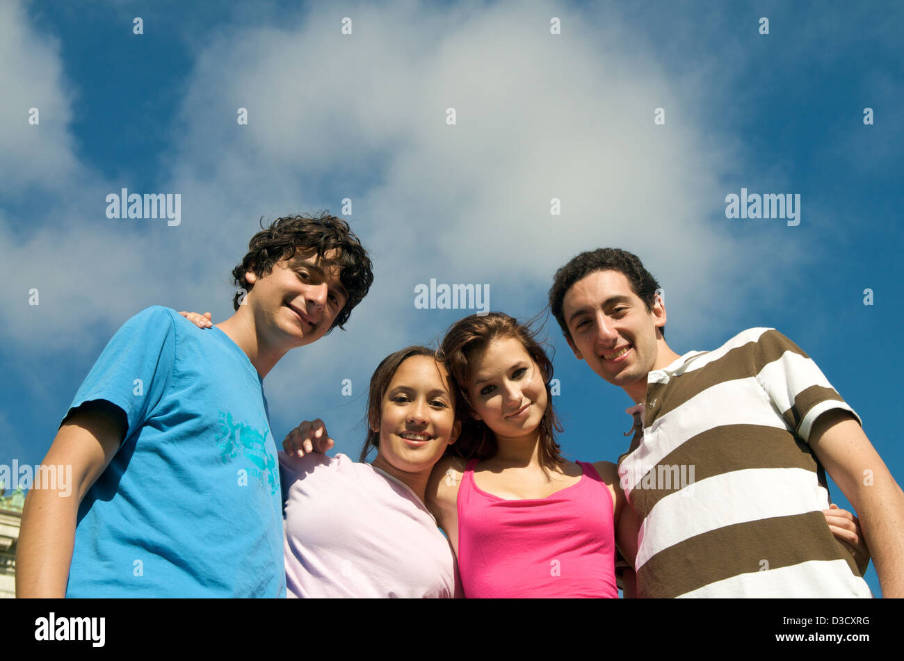 Group of 4 friends under blue sky Stock Photo - Alamy