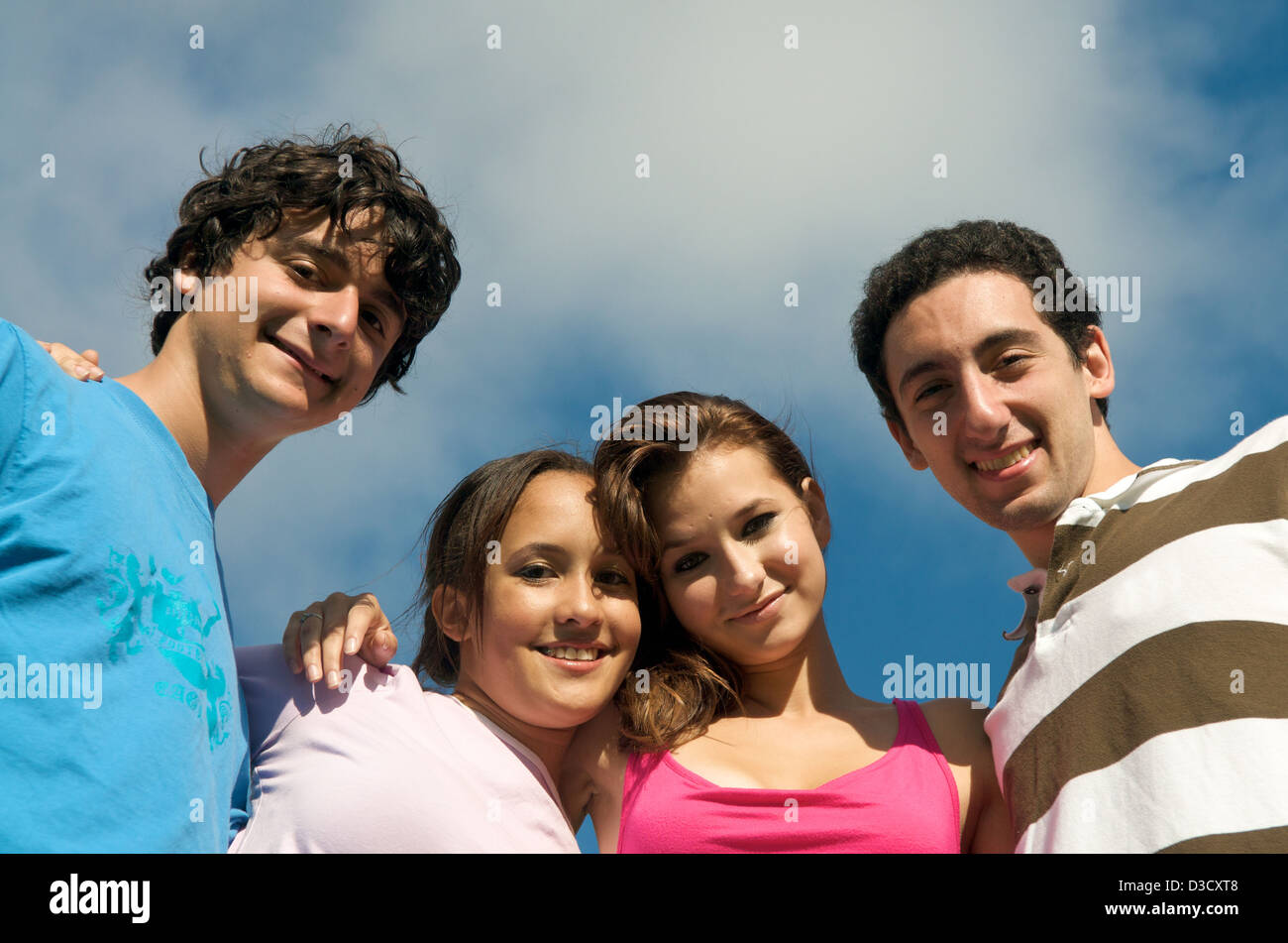 Group of 4 friends under blue sky Stock Photo - Alamy