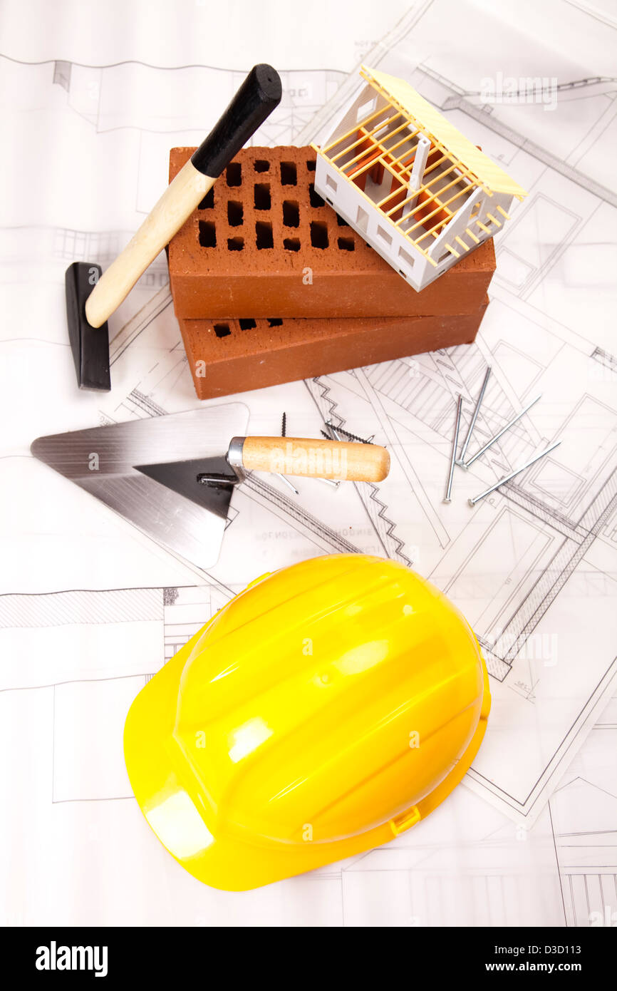 Bricks, trowel tool and Construction plans Stock Photo - Alamy