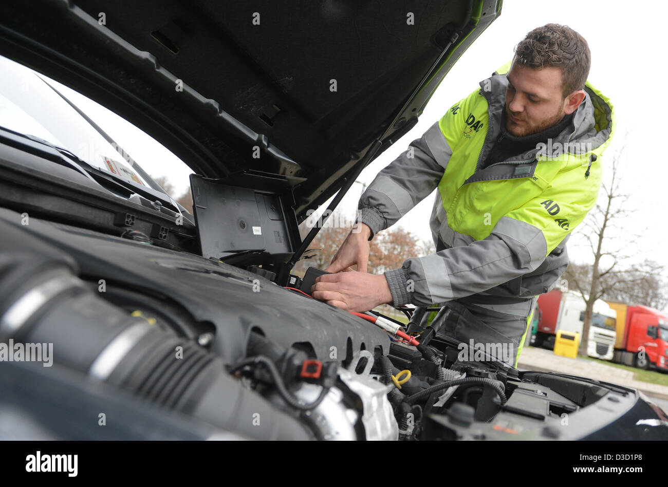 ADAC road patrol driver Kai Maier (L) shows how to short a car battery ...