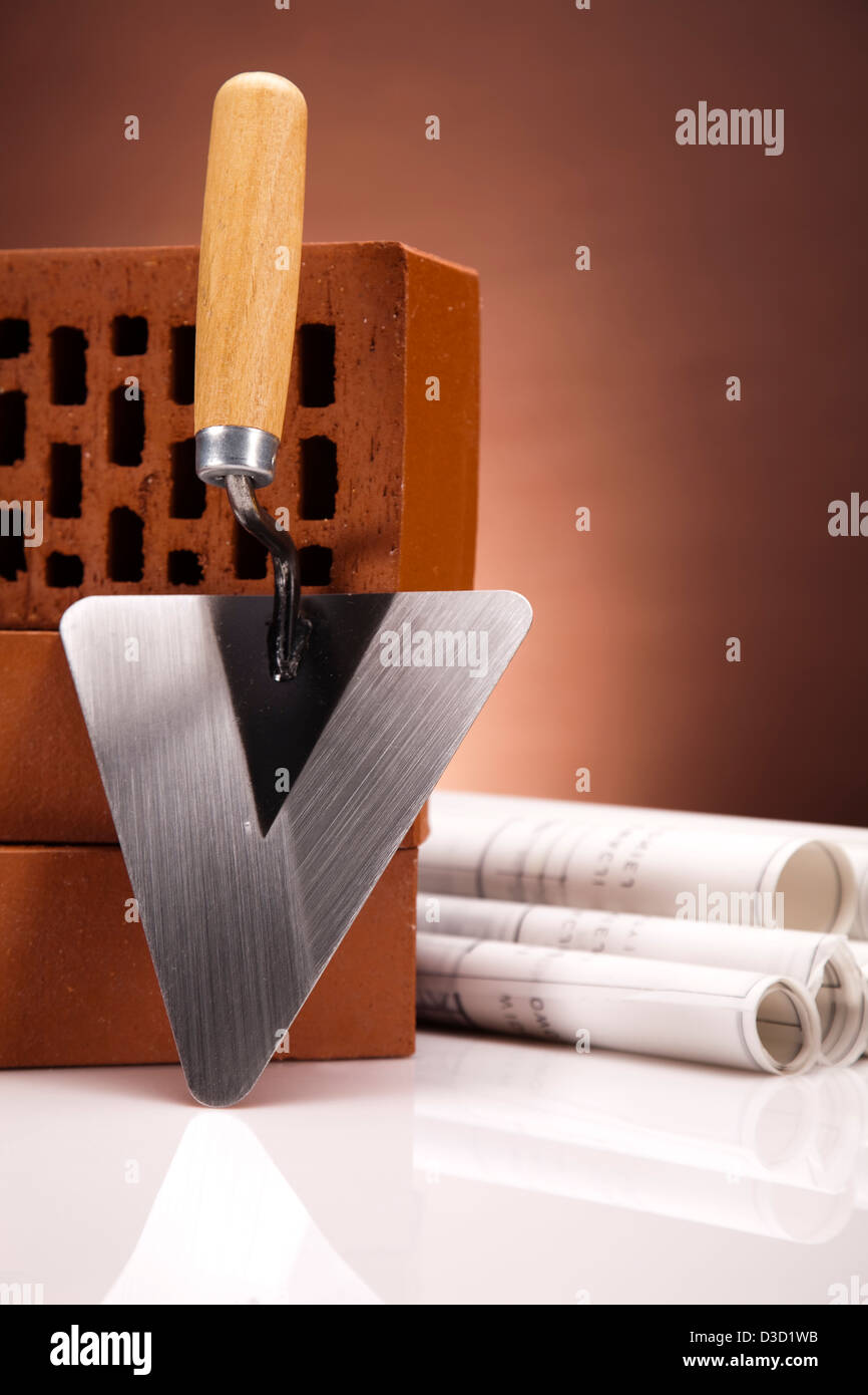 Bricks, trowel tool and Construction plans Stock Photo - Alamy