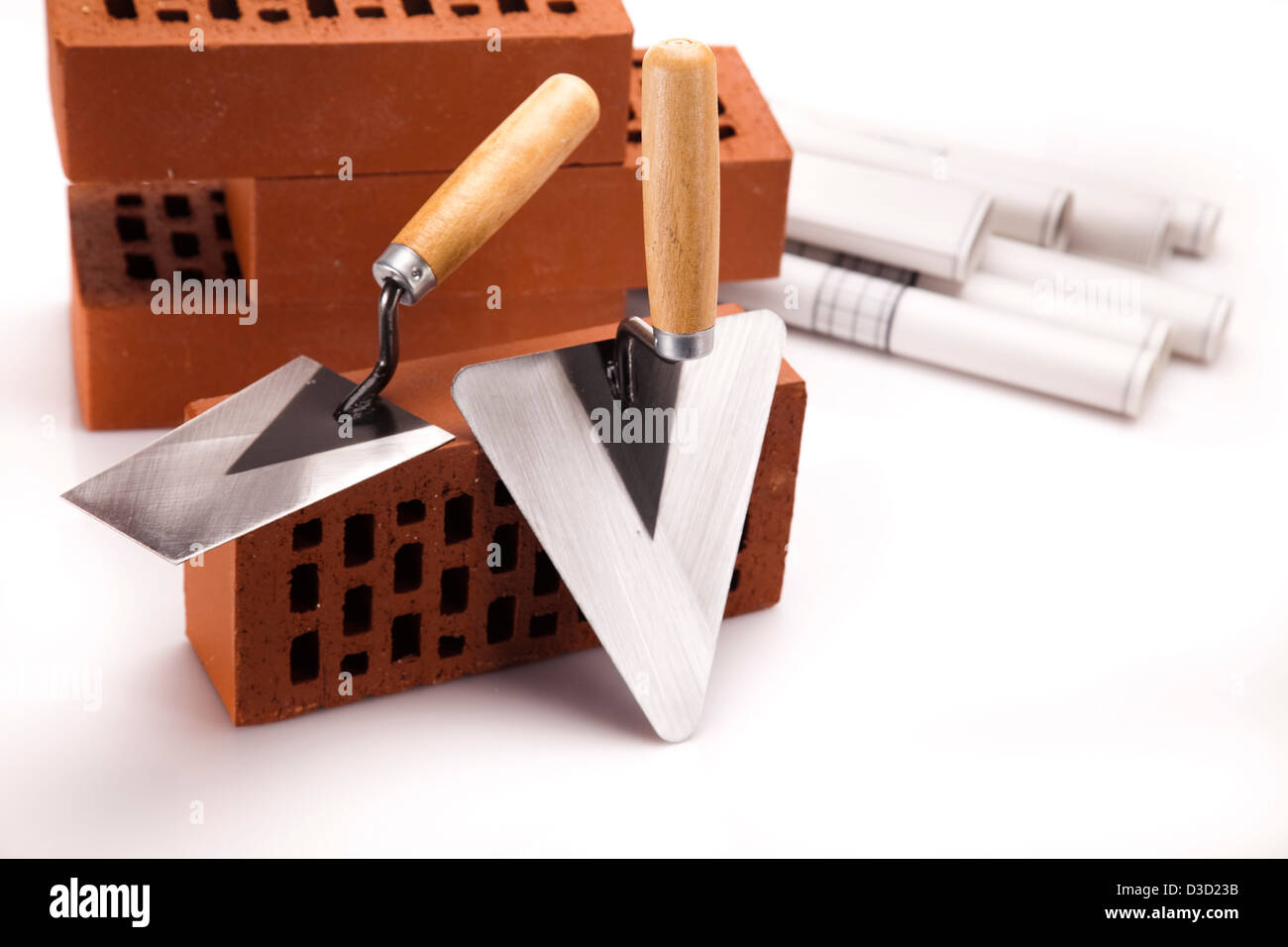 Bricks, trowel tool and Construction plans Stock Photo - Alamy
