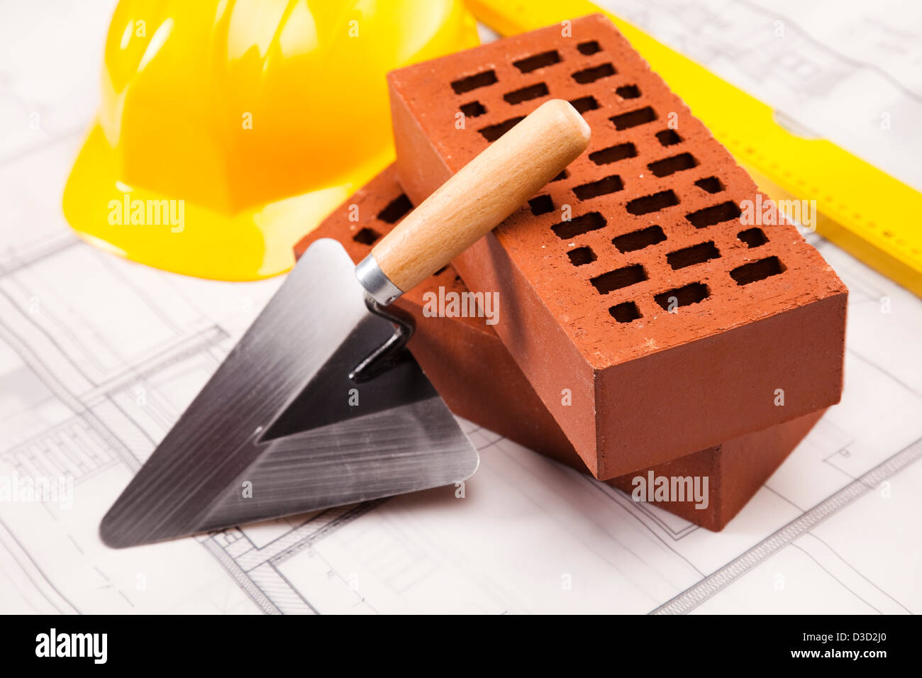 Bricks, trowel tool and Construction plans Stock Photo - Alamy