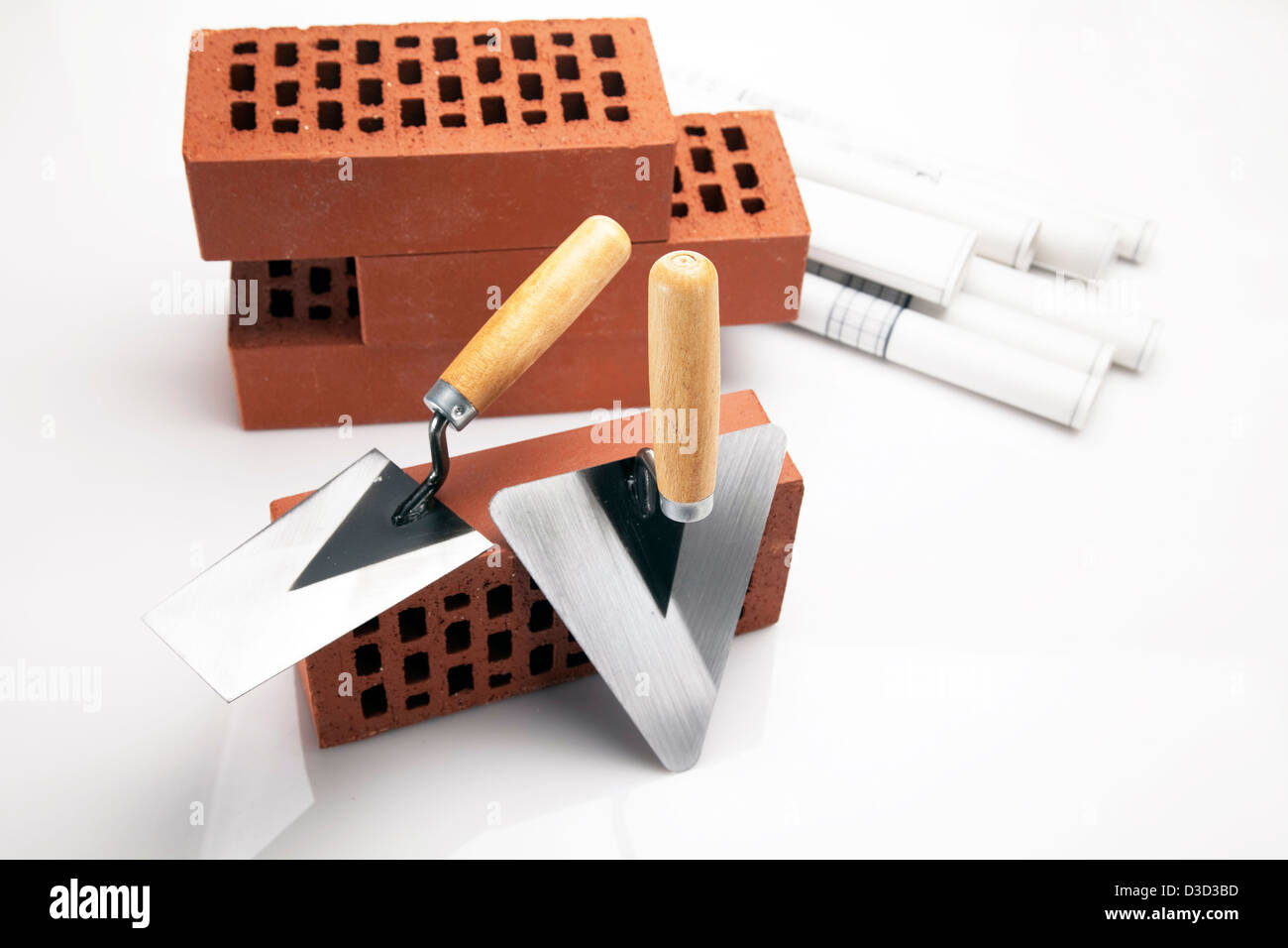 Bricks, trowel tool and Construction plans Stock Photo - Alamy