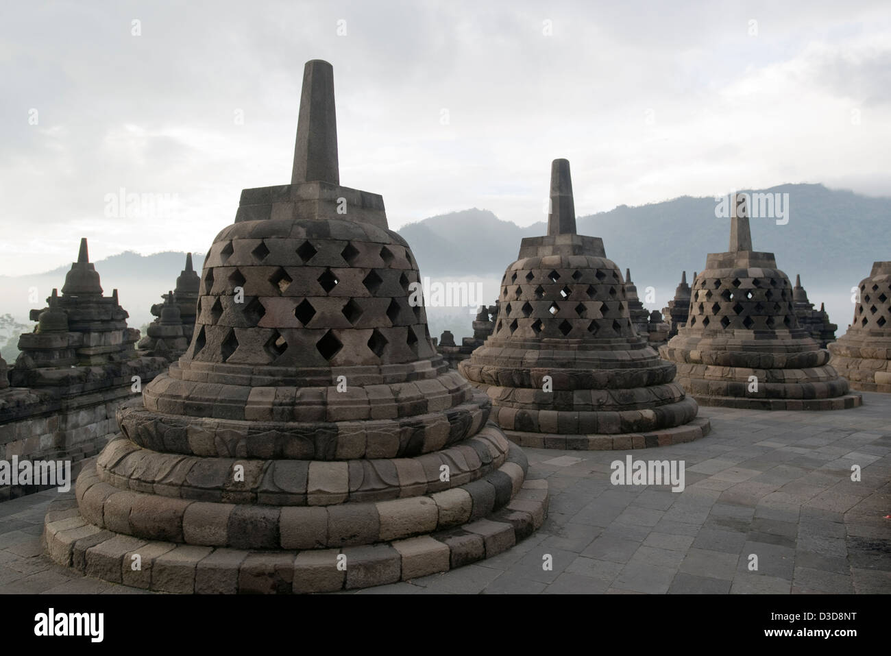 Chortens containing hidden Buddha statues sit on the uppermost plinth ...