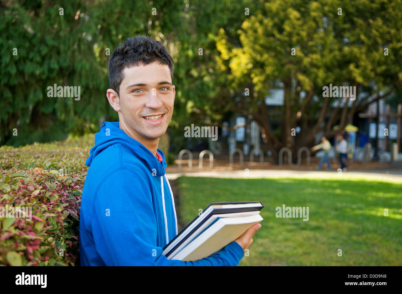 Male student holding textbooks outdoor Stock Photo - Alamy