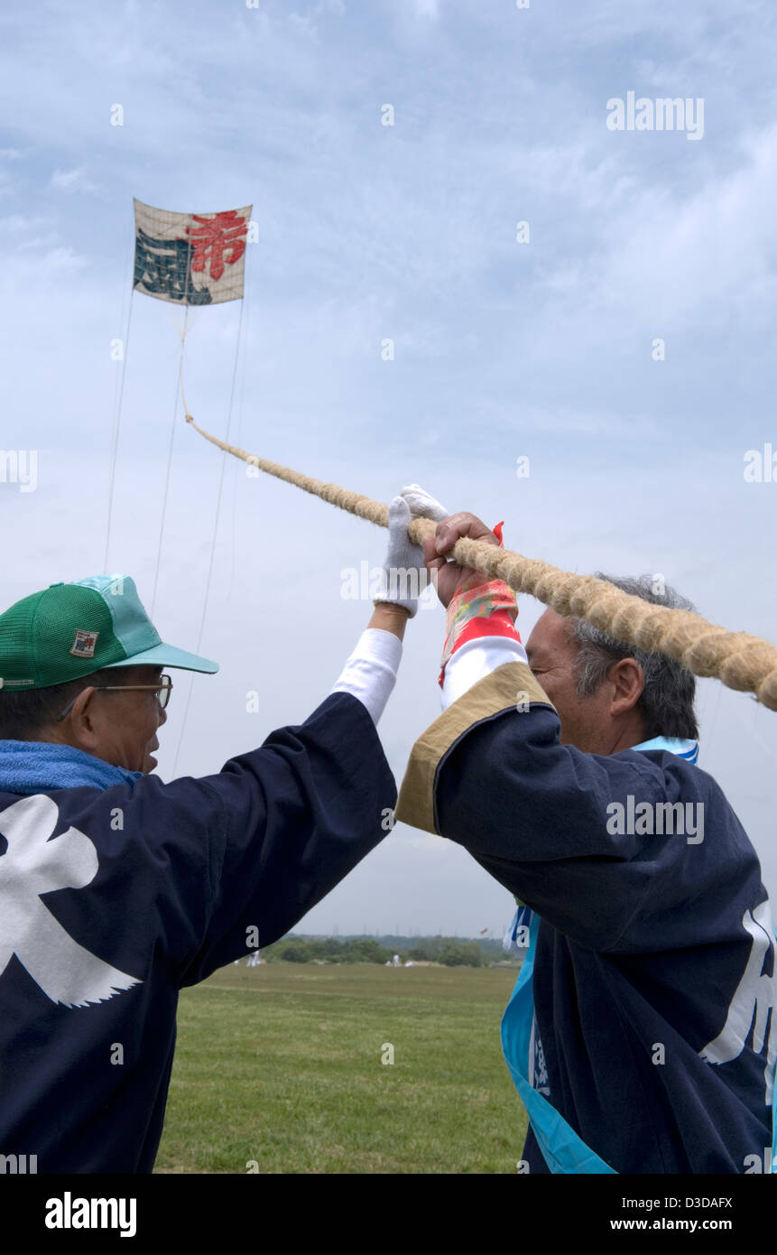 Two men watch giant high-flying paper and bamboo kite weighing 950 ...