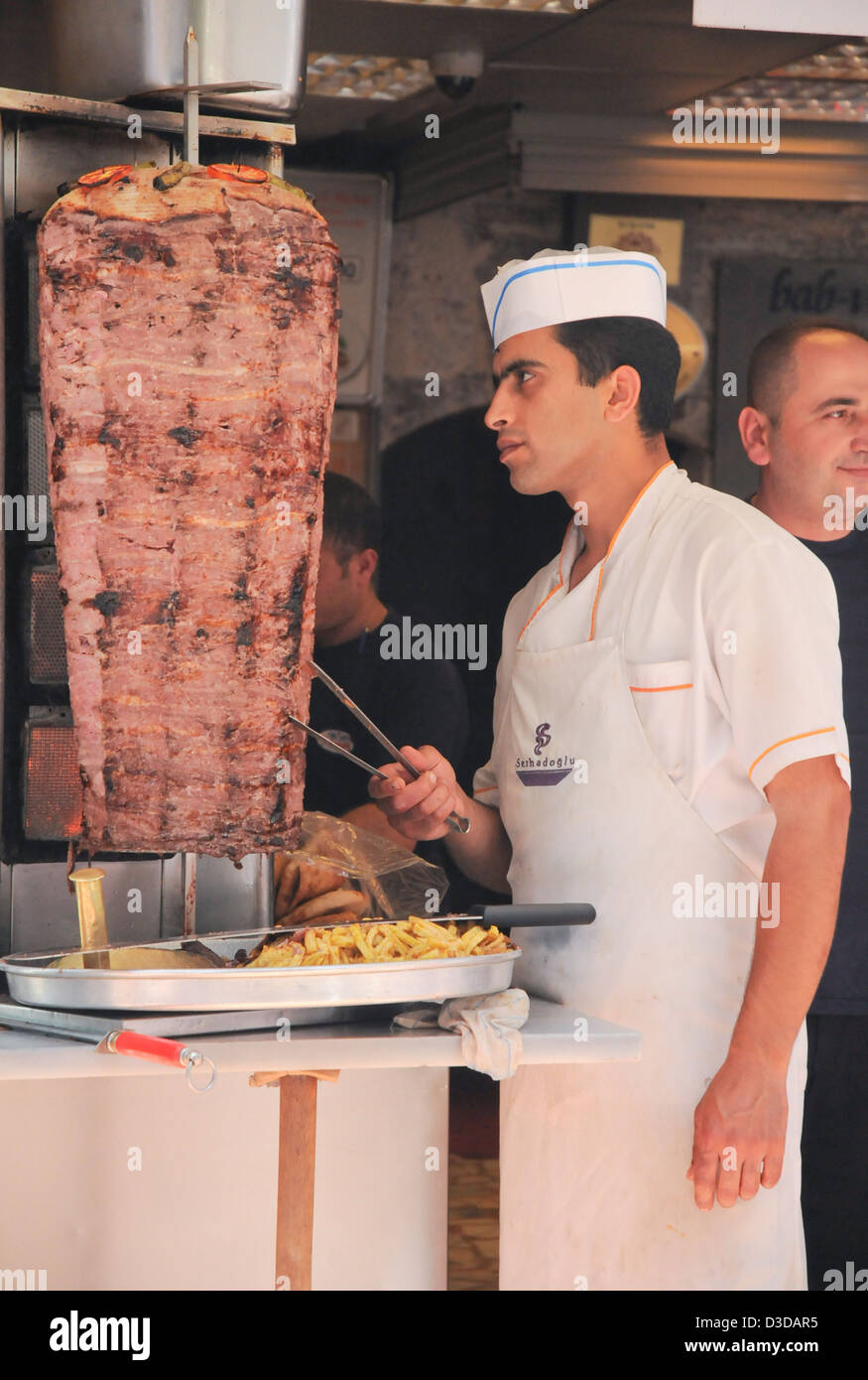 Döner meat being scrapped from the spit for a kebab Stock Photo - Alamy