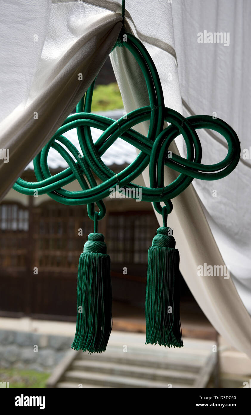 A green braided rope pattern with tassels hanging below a banner at ...