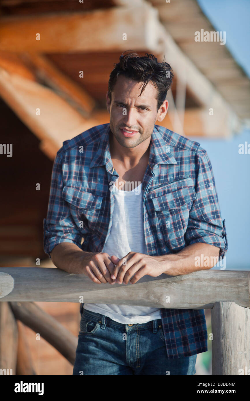 Portrait of a man leaning against a railing Stock Photo - Alamy