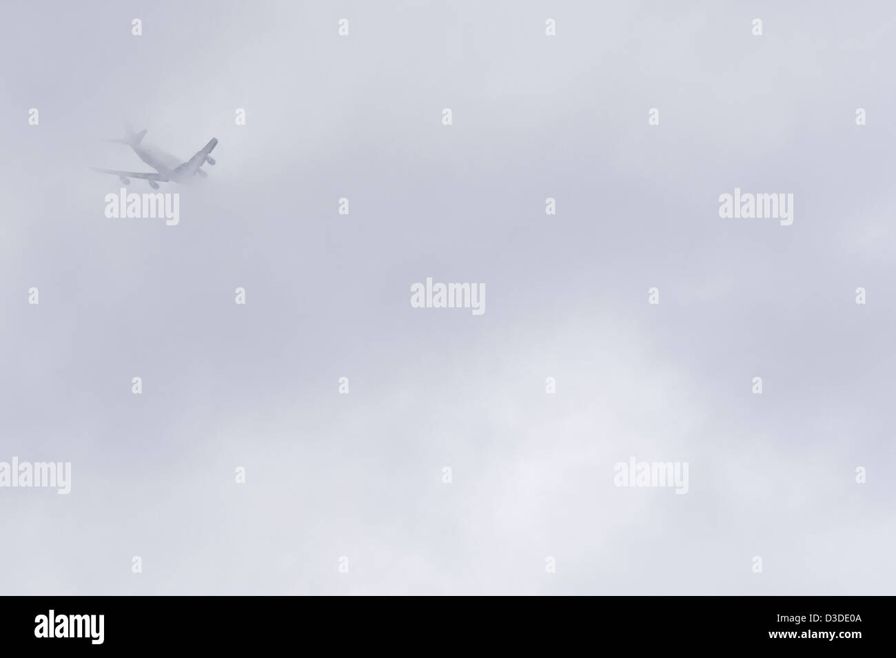 Jet airliner flying through low clouds Stock Photo - Alamy