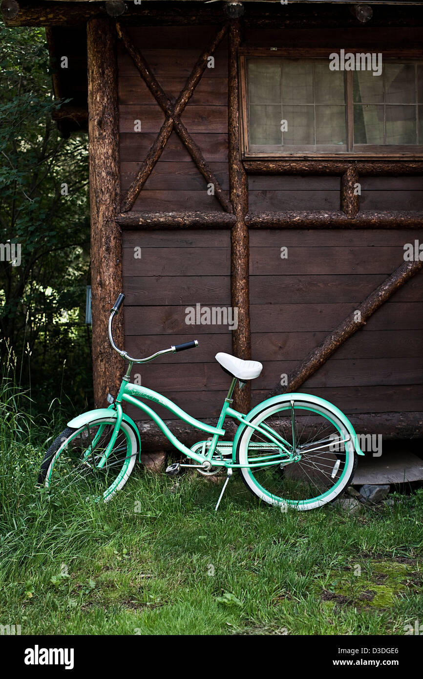 Childs bike parked on log cabin exterior in Montana, USA Stock Photo ...