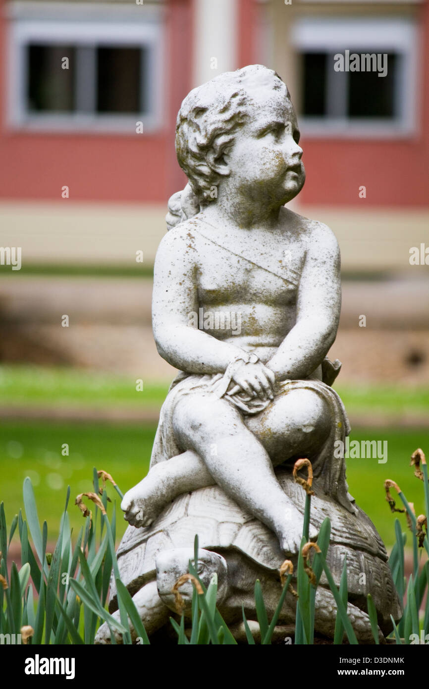 Close view of a statue of a young child sitting on a urban park Stock ...