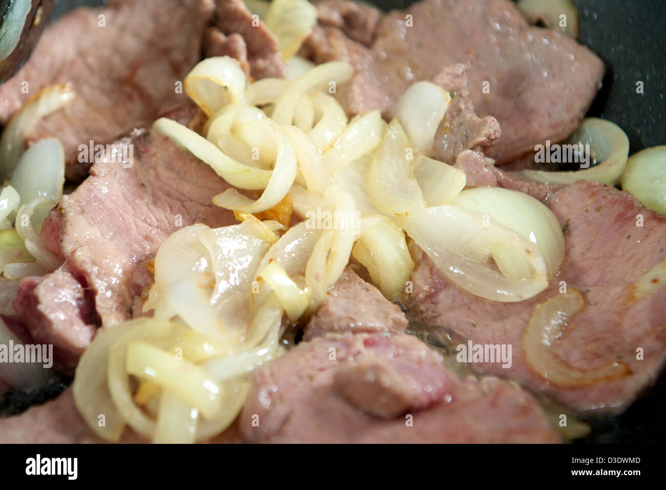 Stir frying onion beef in a wok Stock Photo - Alamy
