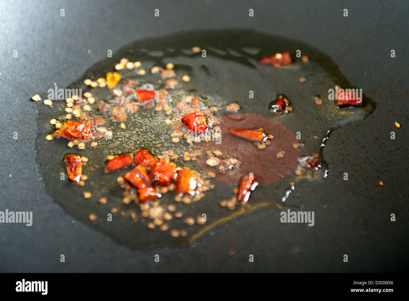 Frying spicy chilly pepper in oil in a wok Stock Photo - Alamy