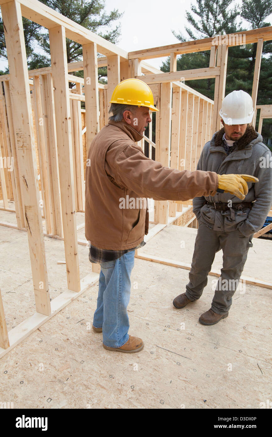 Construction supervisor discussing home construction with a carpenter ...