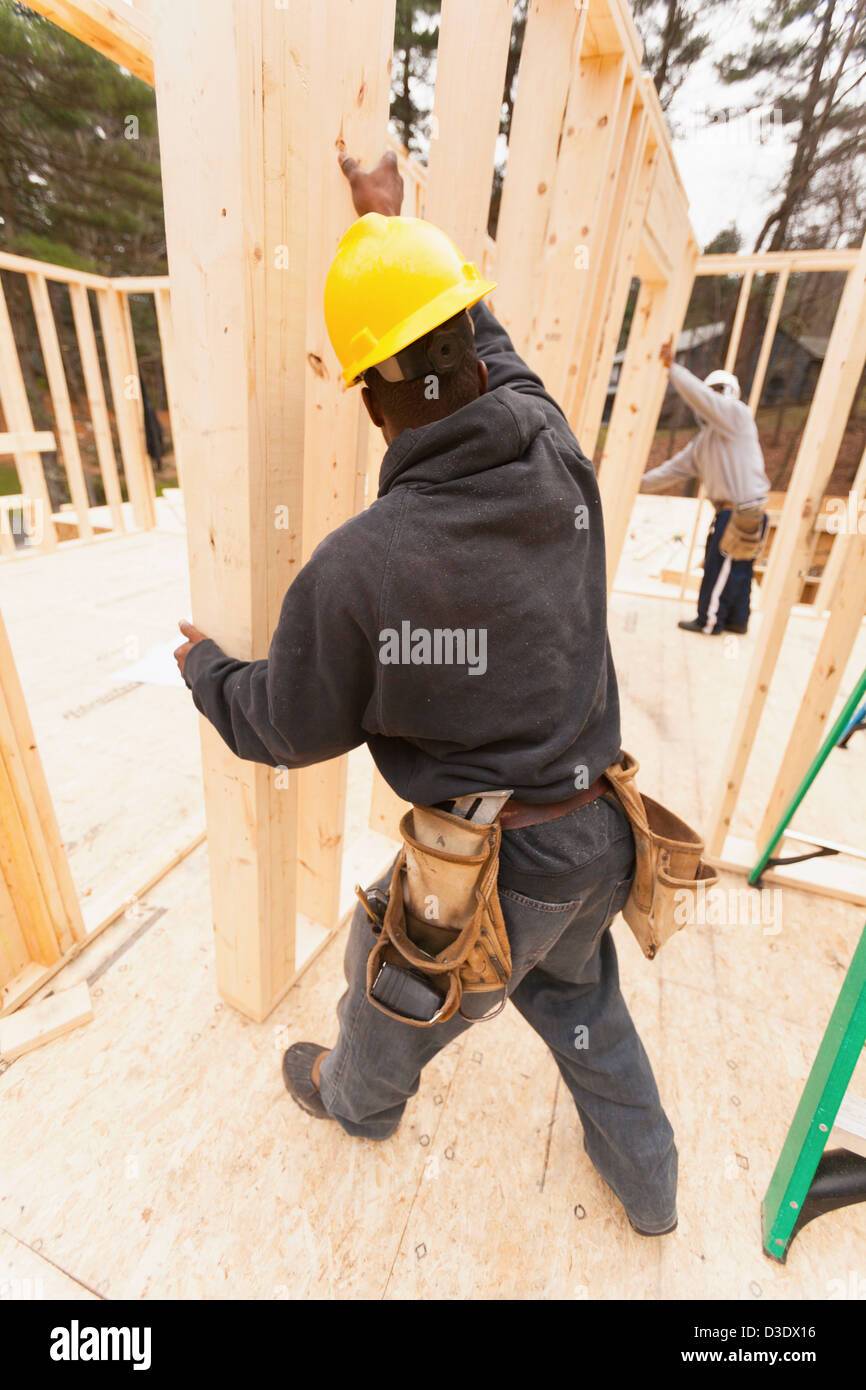 Two carpenters raising wall section into place Stock Photo - Alamy