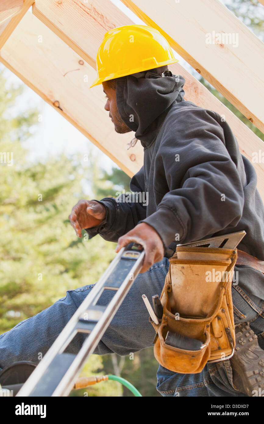 Carpenter using a level in house construction Stock Photo - Alamy