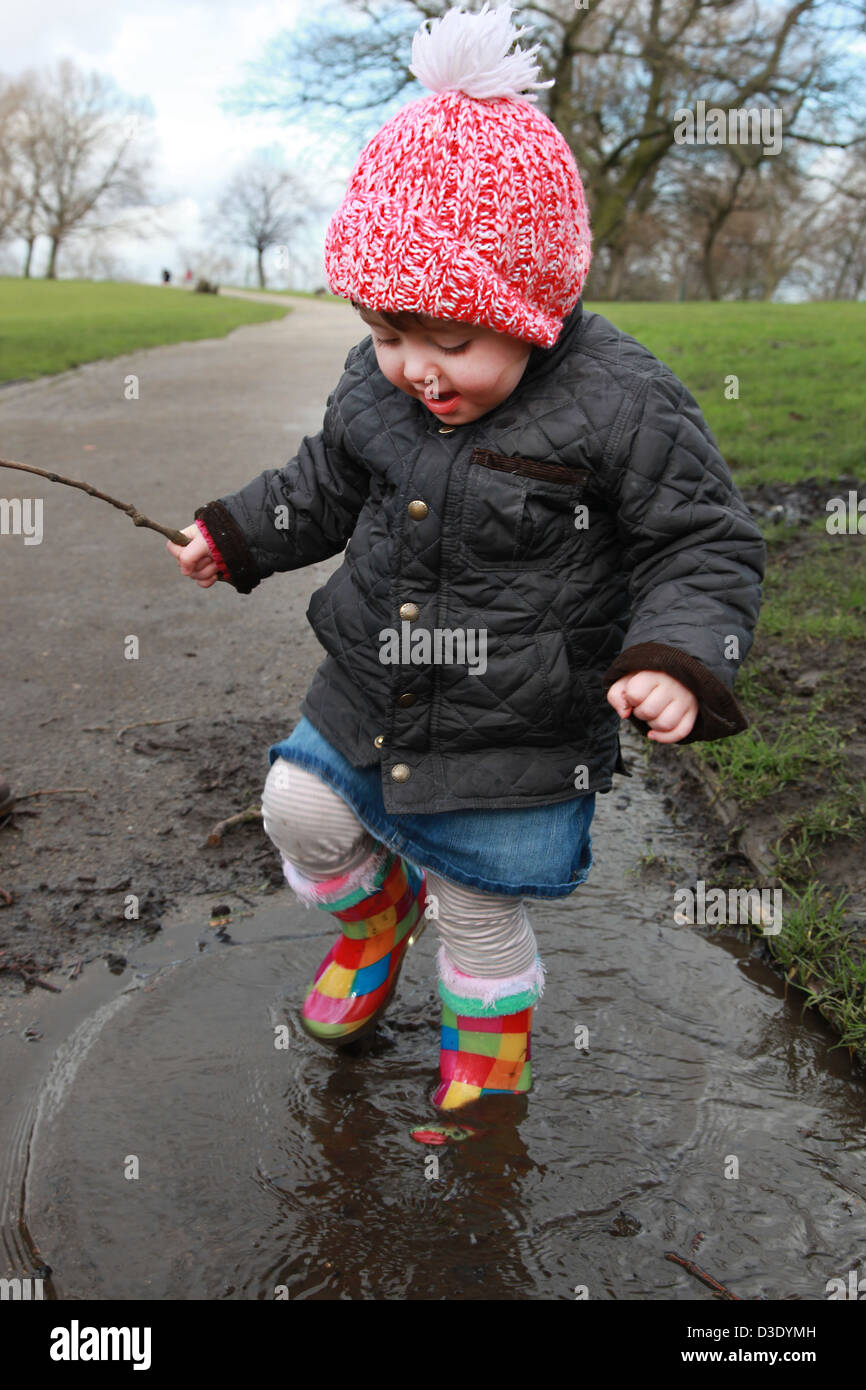 Toddler playing in a puddle Stock Photo - Alamy