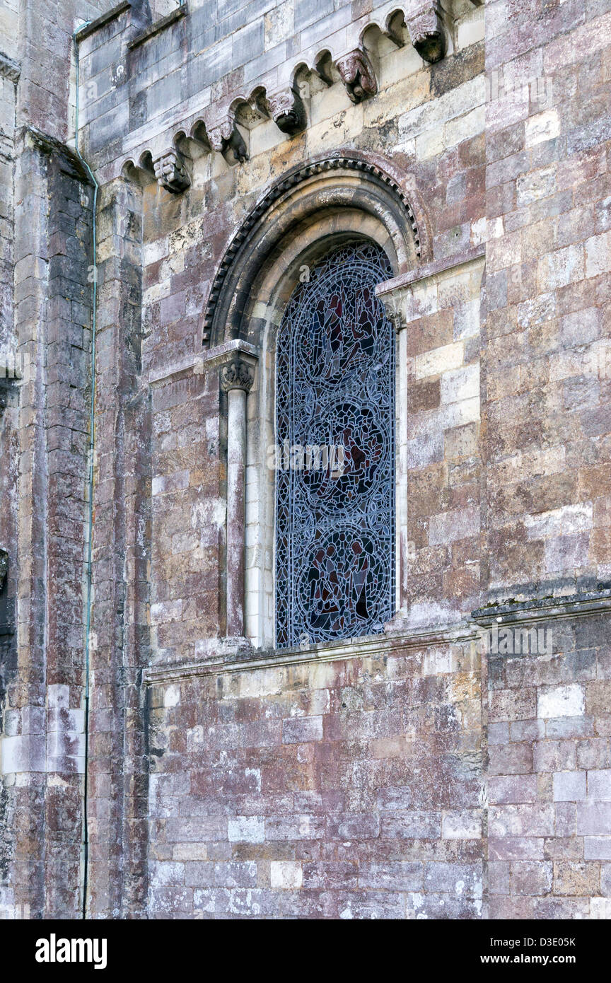 Stained glass window set in old stone wall at Romsey abbey Hampshire ...