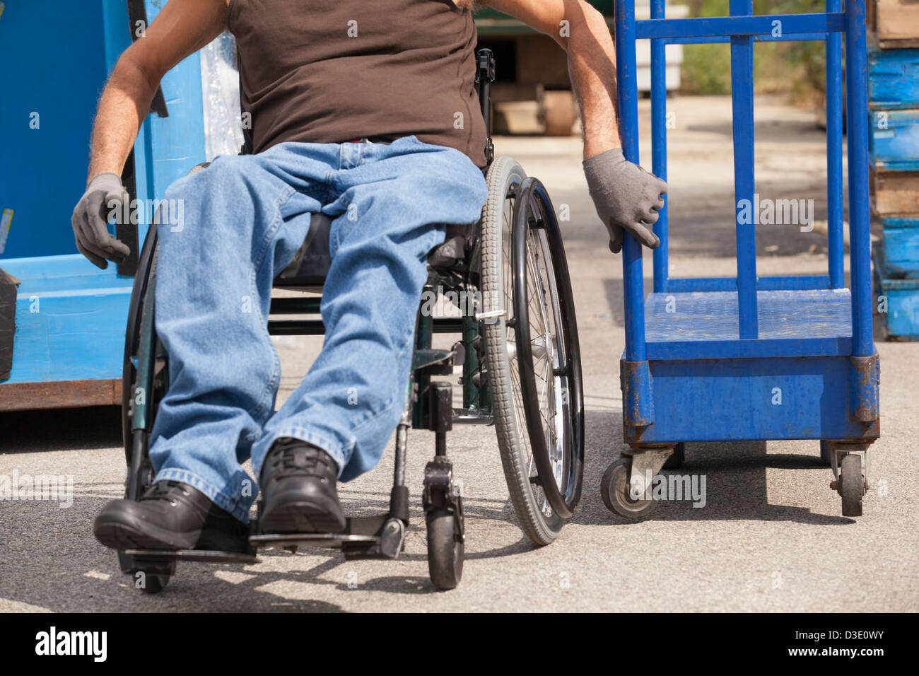 Loading dock worker with spinal cord injury in a wheelchair moving a ...