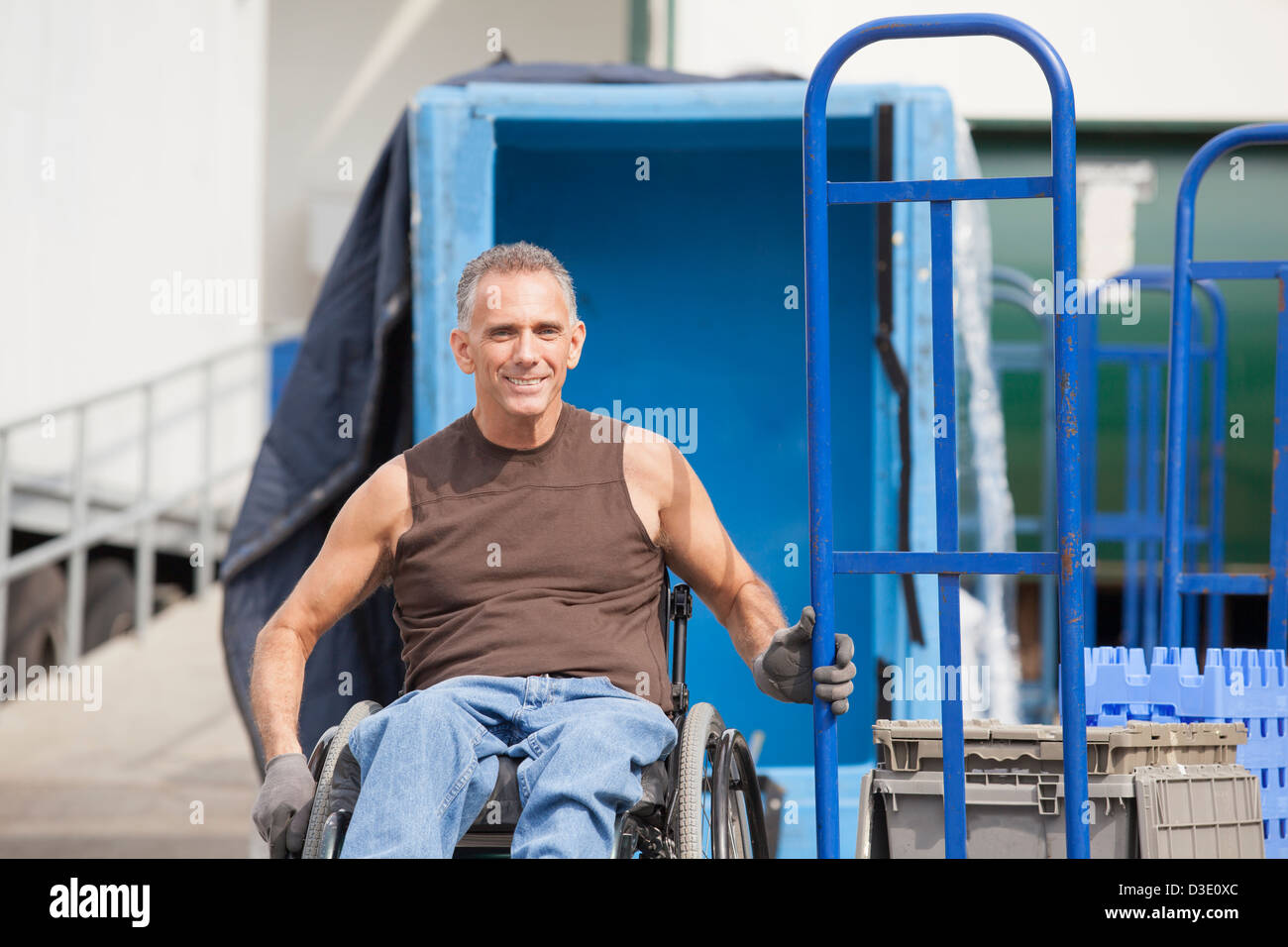 Loading dock worker with spinal cord injury in a wheelchair moving a ...