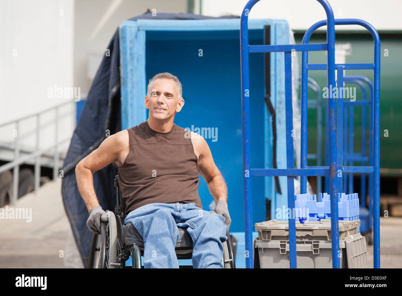 Loading dock worker with spinal cord injury in a wheelchair in storage ...