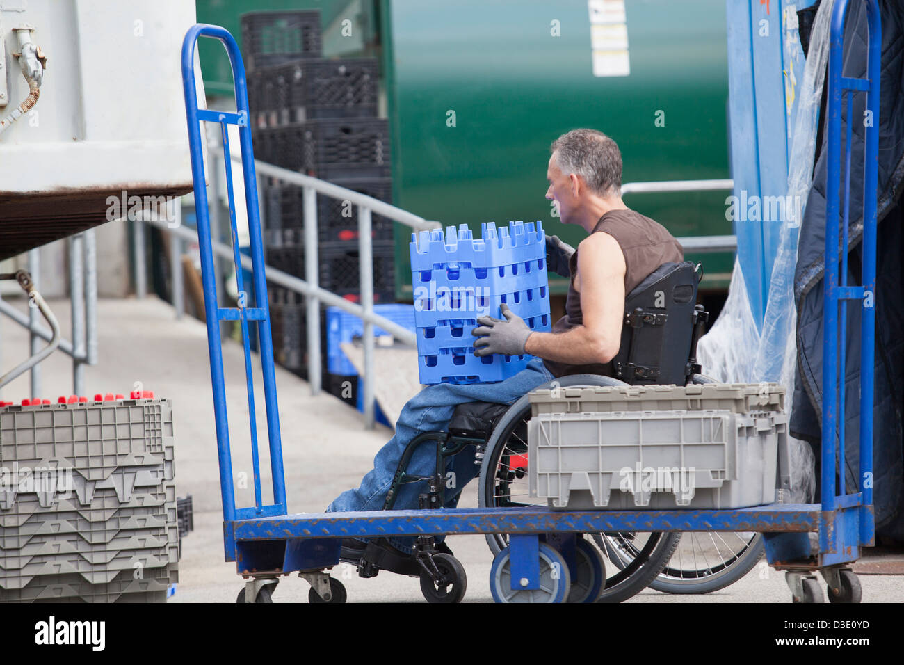 Loading dock worker with spinal cord injury in a wheelchair moving ...