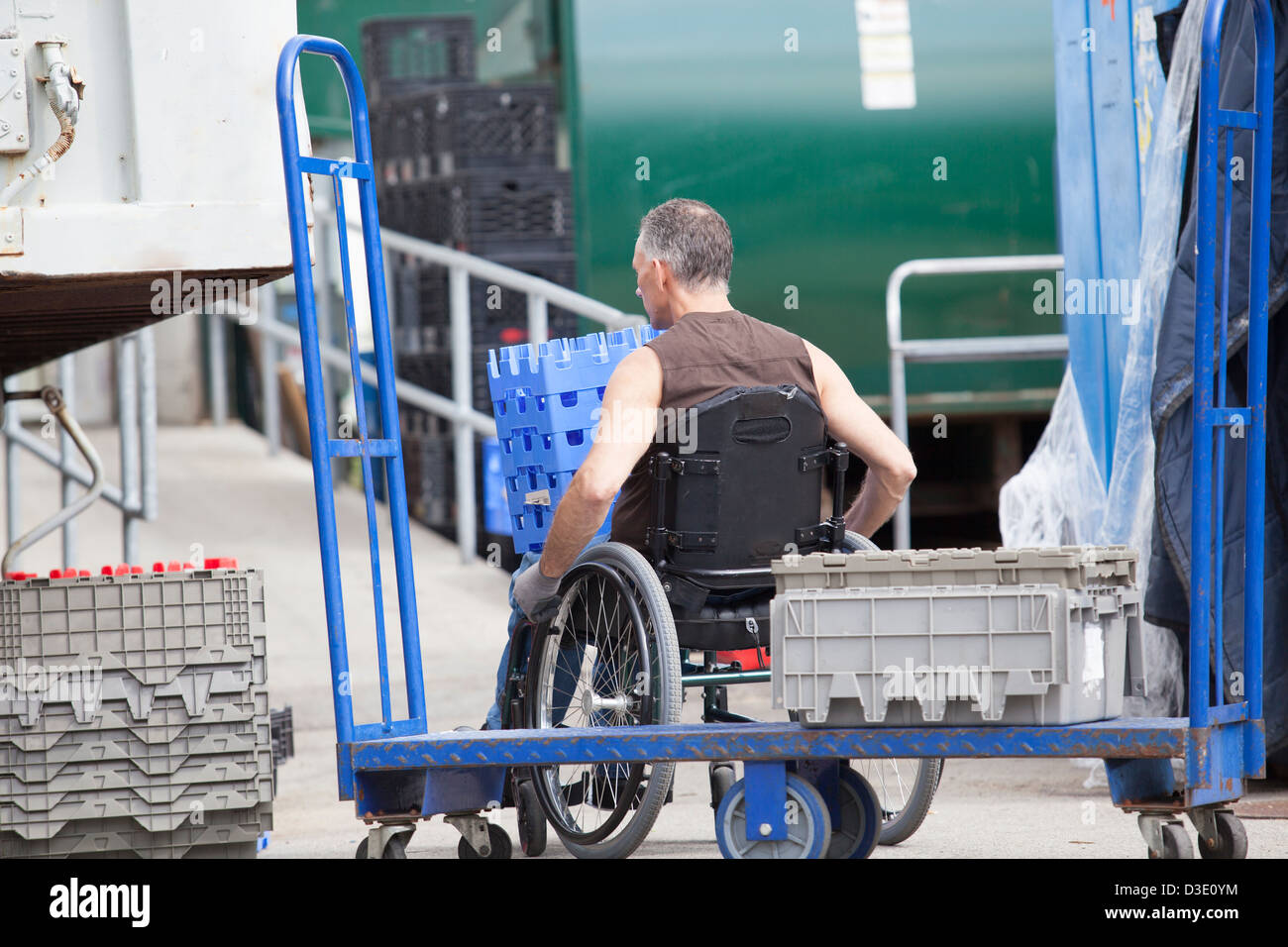 Loading dock worker with spinal cord injury in a wheelchair moving ...