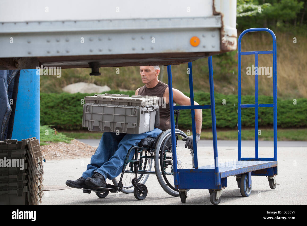 Loading dock worker with spinal cord injury in a wheelchair moving ...