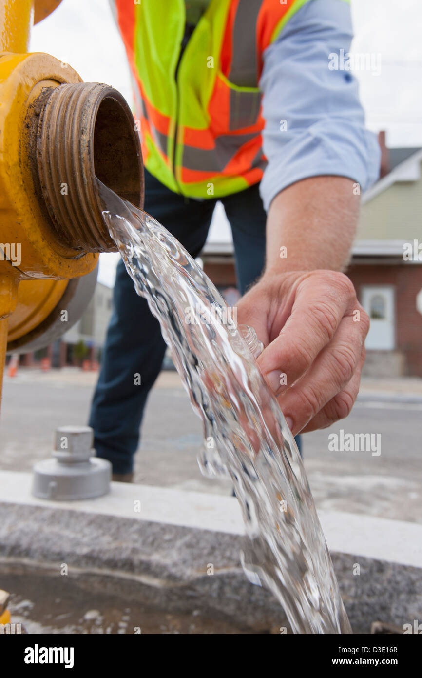 Engineer taking a water sample from a street hydrant Stock Photo - Alamy