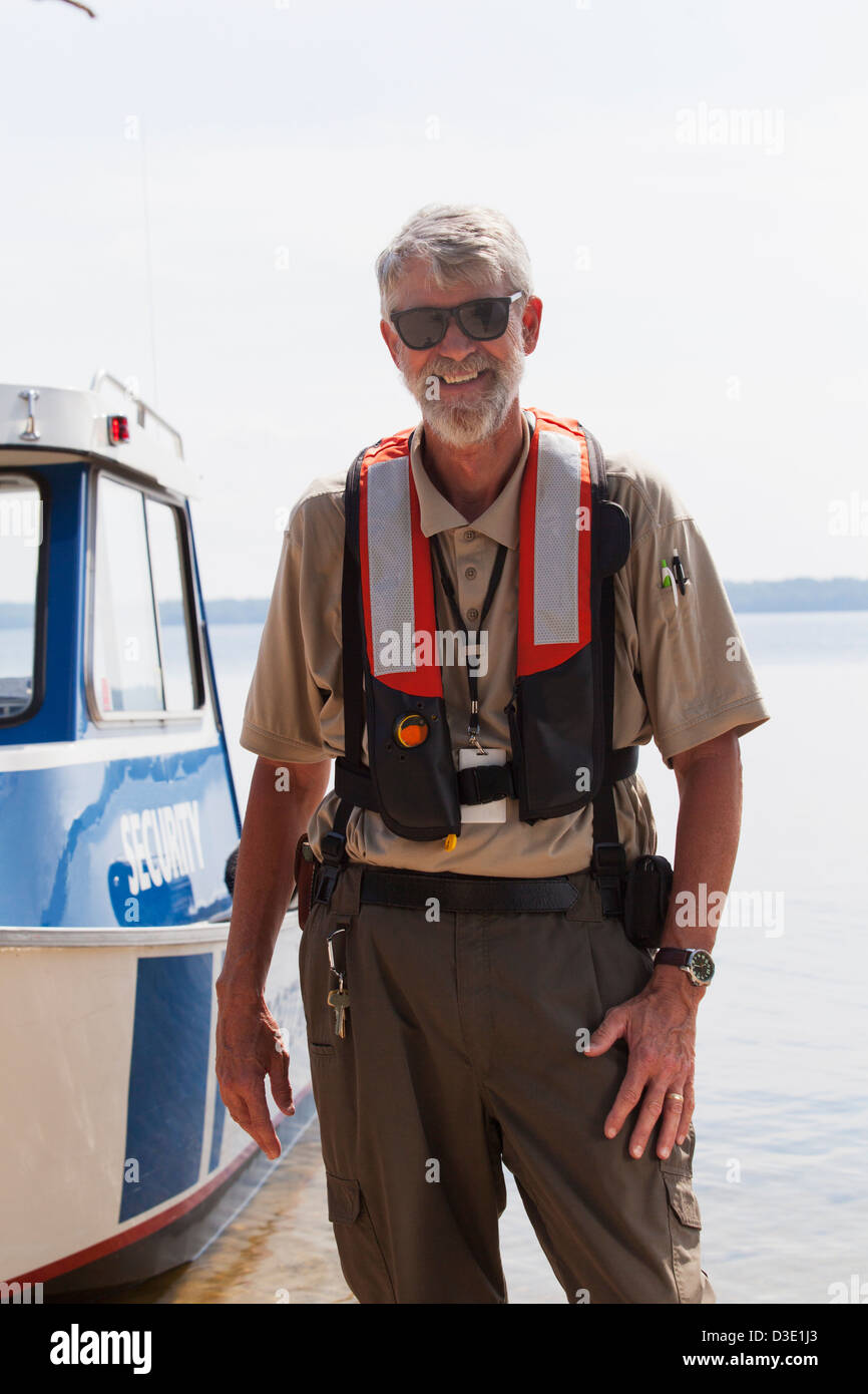 Portrait of a public works engineer standing near a service boat and ...