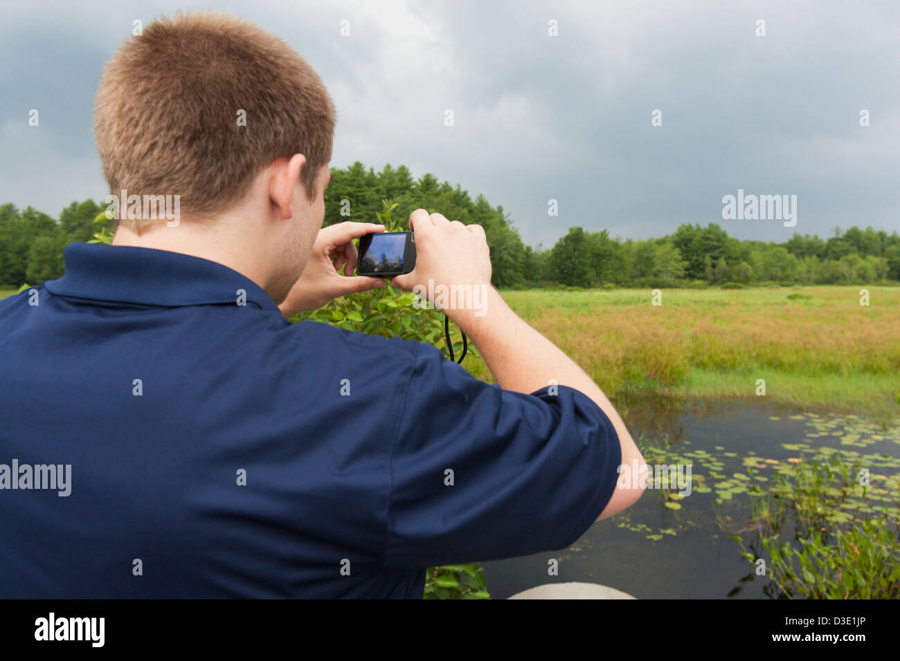 Public works engineer photographing swamp near reservoir, Portland ...