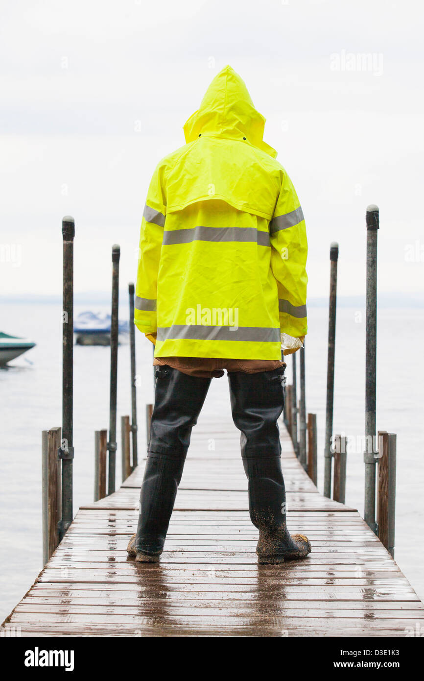 Public works engineer on dock carrying water sample packet from lake ...