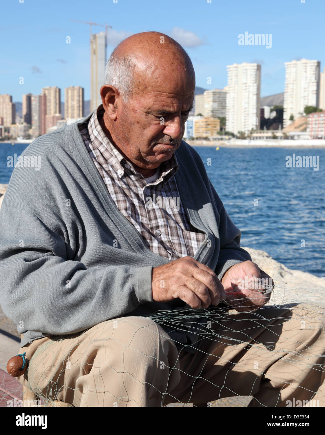 Old man mending fishing nets in Benidorm Harbour Spain Stock Photo - Alamy
