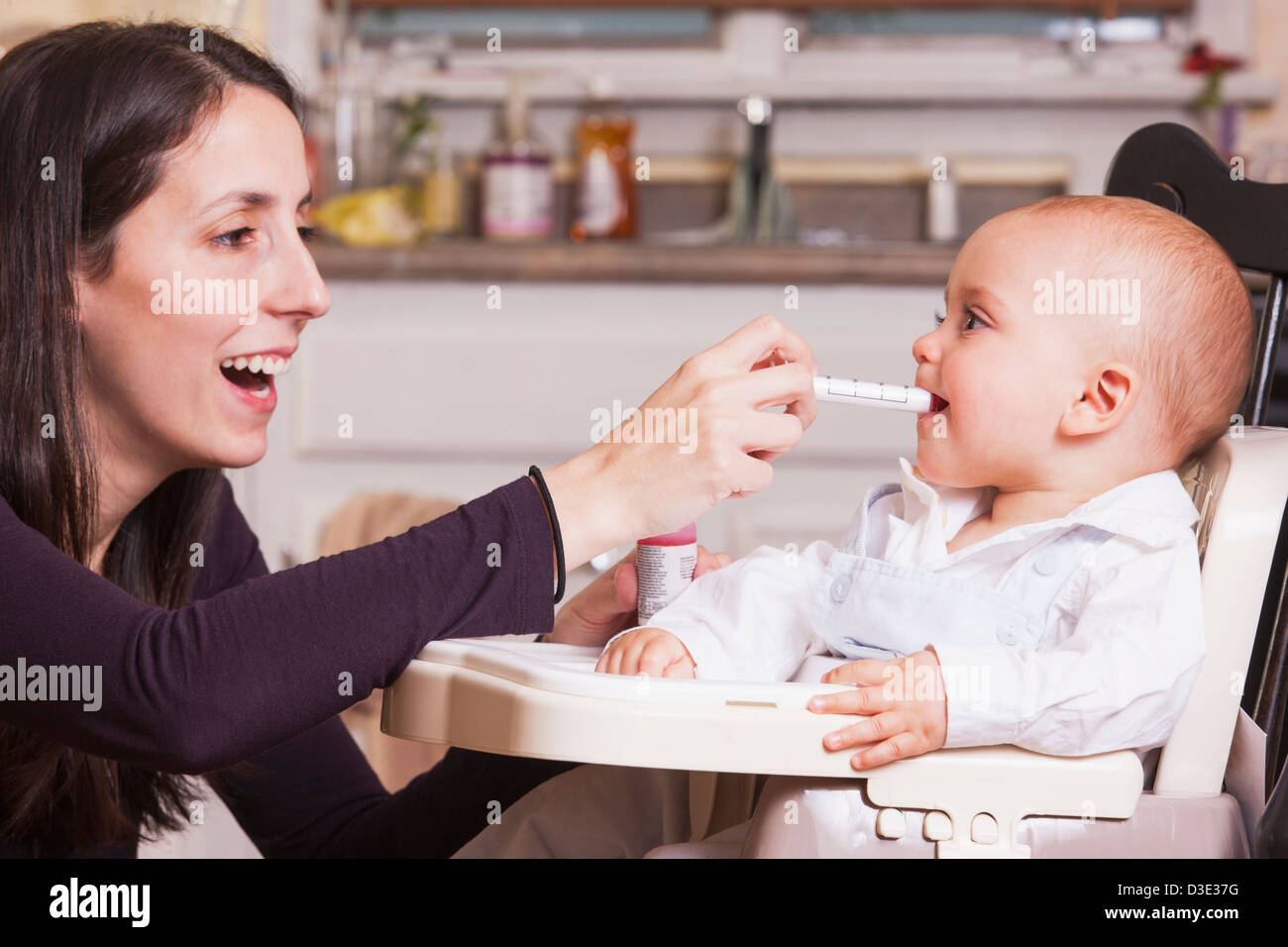 Mother giving medicine to her son Stock Photo - Alamy