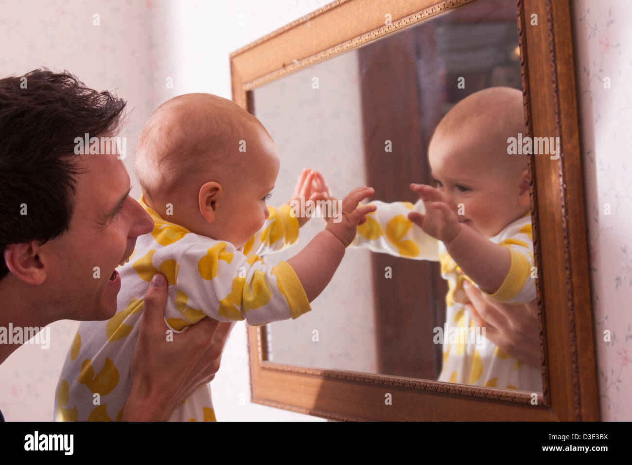 Father holding up his son to a mirror Stock Photo - Alamy