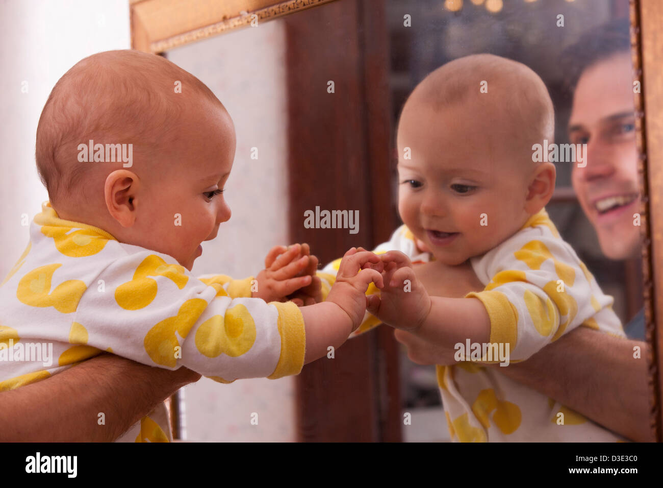 Father holding up his son to a mirror Stock Photo - Alamy