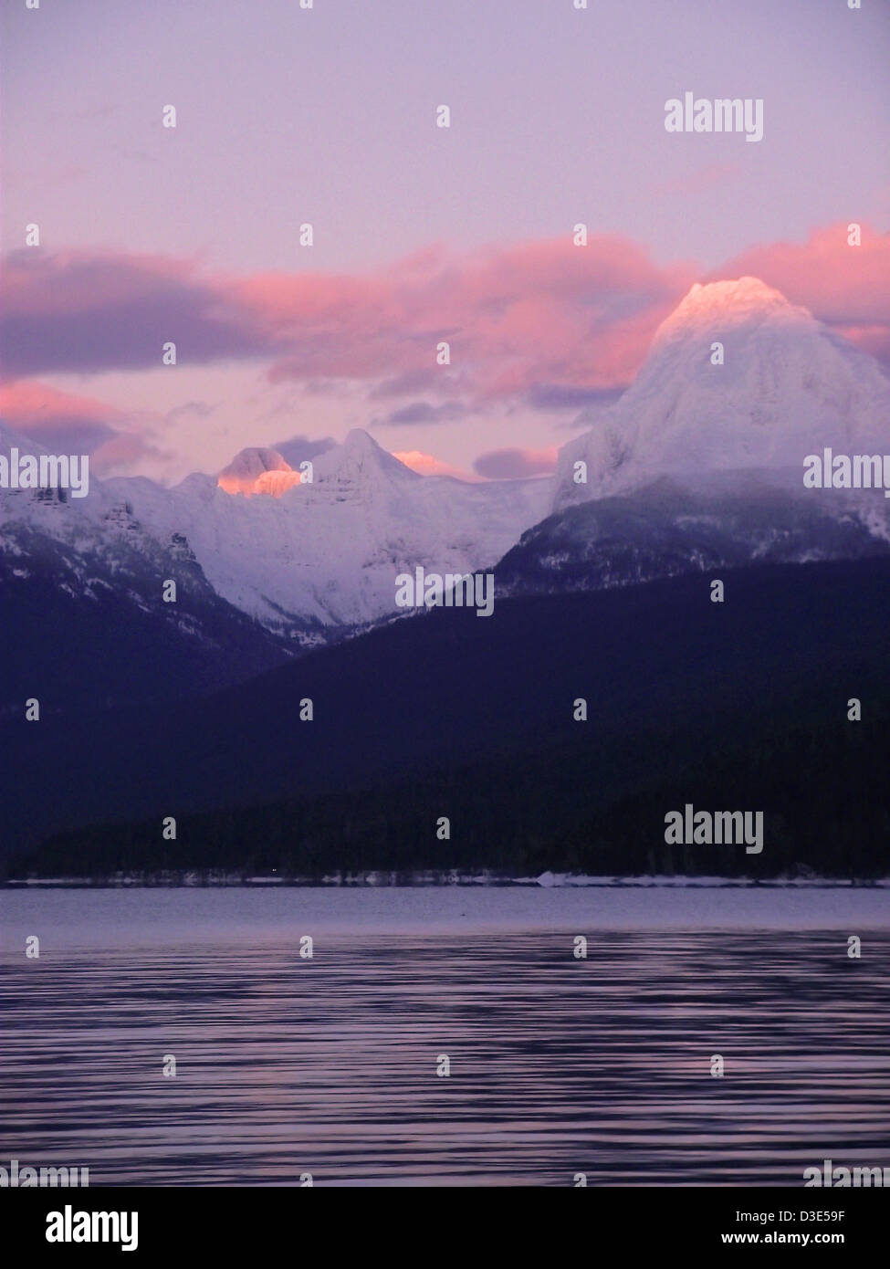 Alpenglow reflects off the snow-capped peaks surrounding Lake McDonald ...