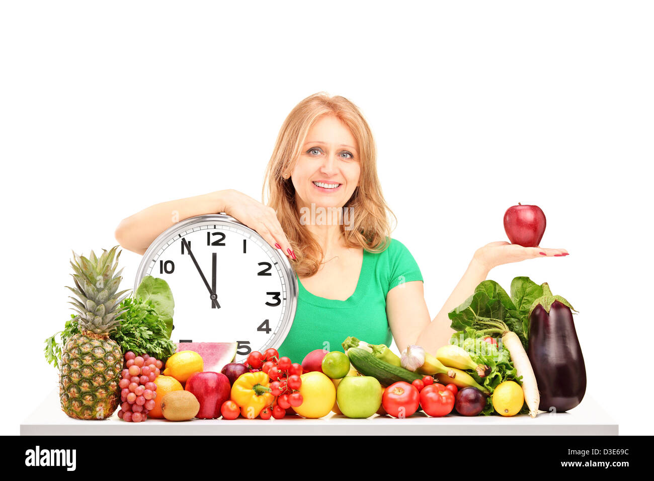 Woman with red apple, clock and fruit and vegetables on a table ...