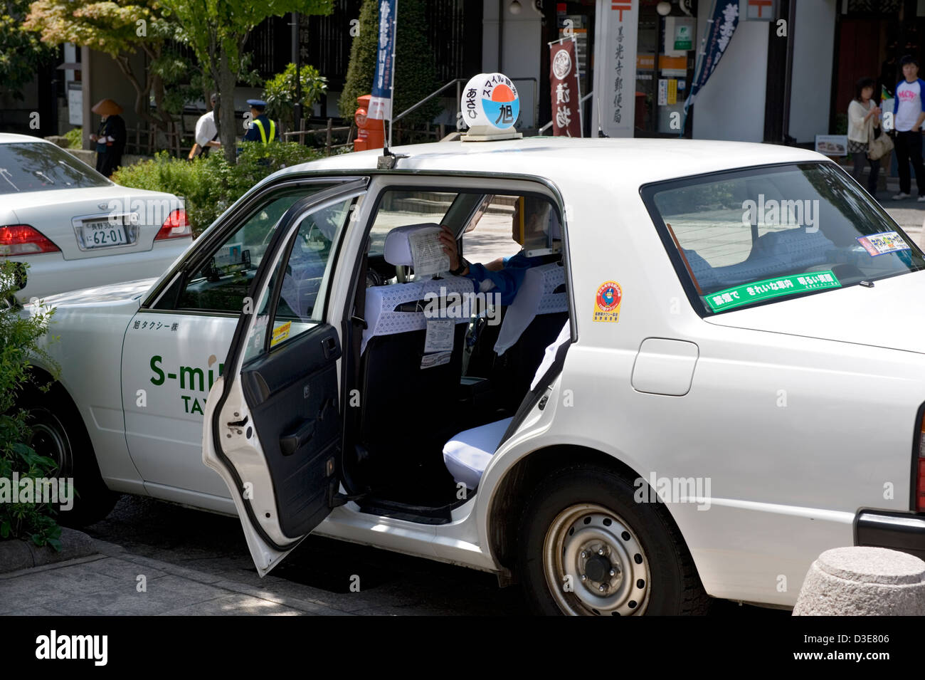 Japanese taxi cab waiting for passenger with left-rear door open. Clean ...