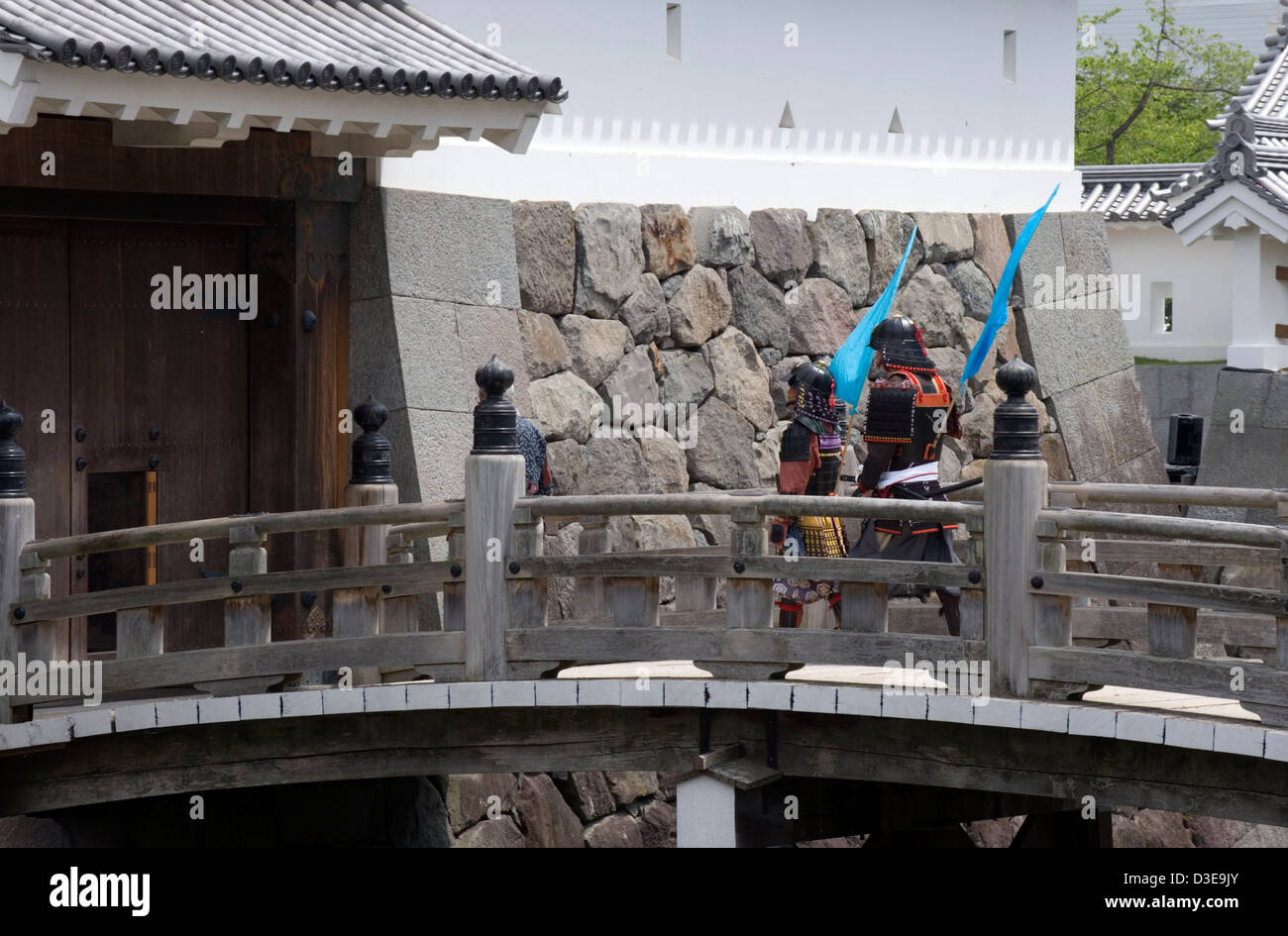 Samurai warriors wearing traditional armor crossing moat bridge at ...