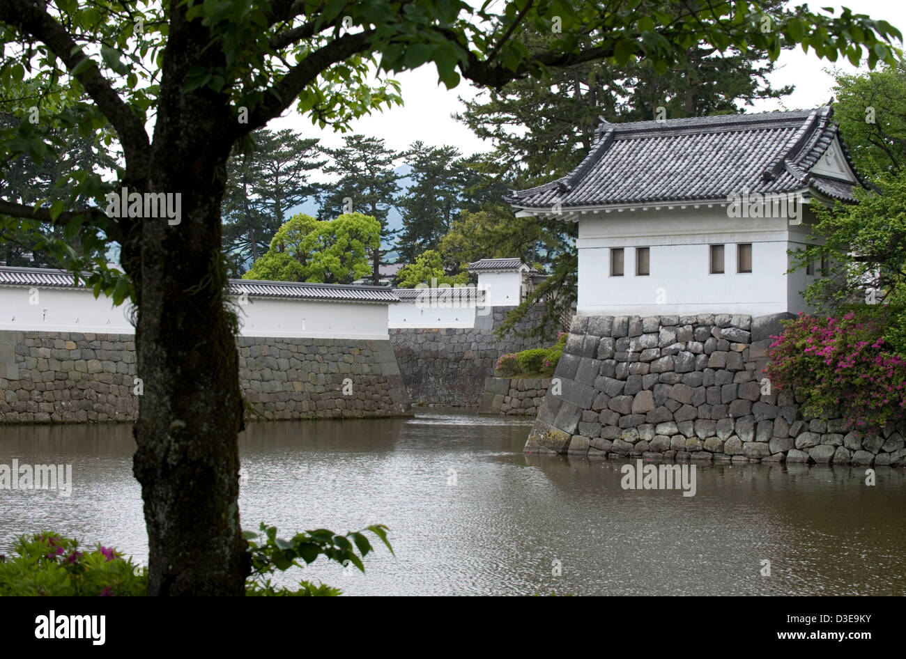 Water-filled moat with guard tower and stone fortress walls at Odawara ...