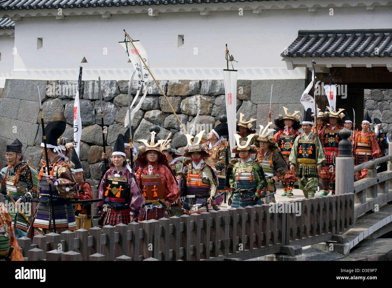 Samurai warriors wearing traditional armor crossing moat bridge at ...