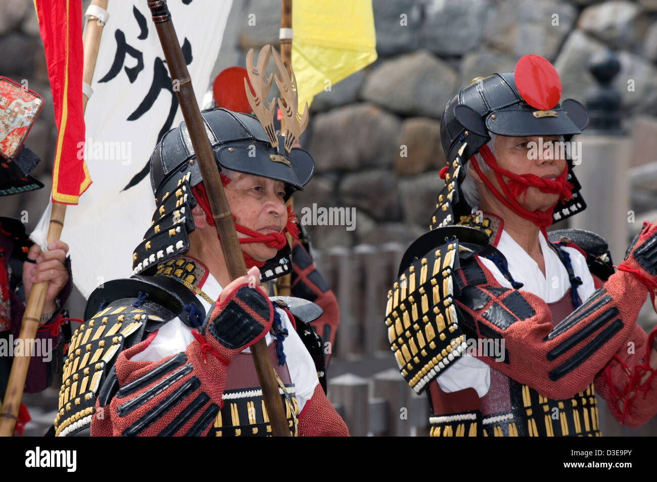 Elderly samurai warriors wearing traditional armor and carrying banners ...