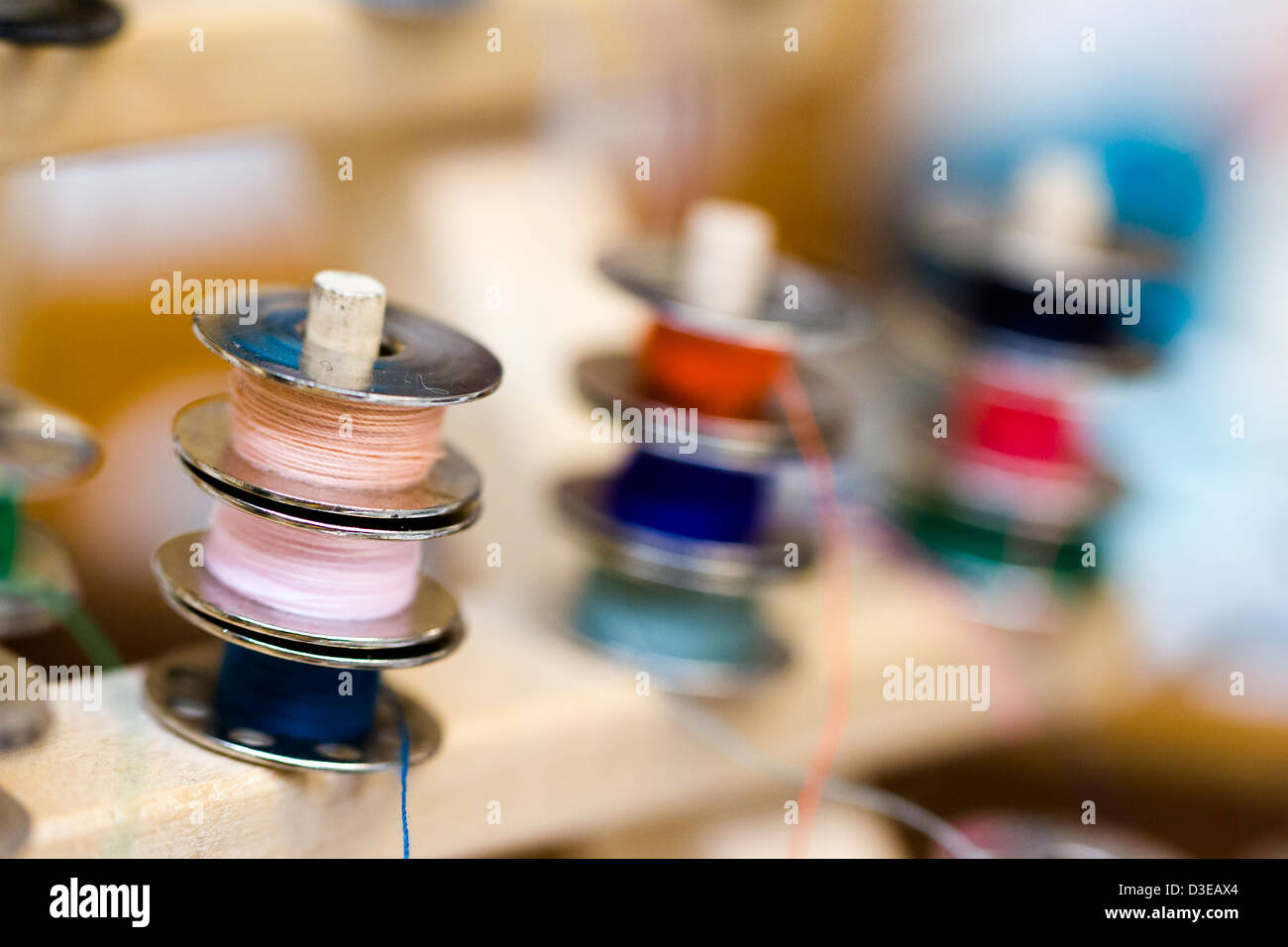 Colorful bobbins of thread on bobbin stand in tailor shop Stock Photo ...